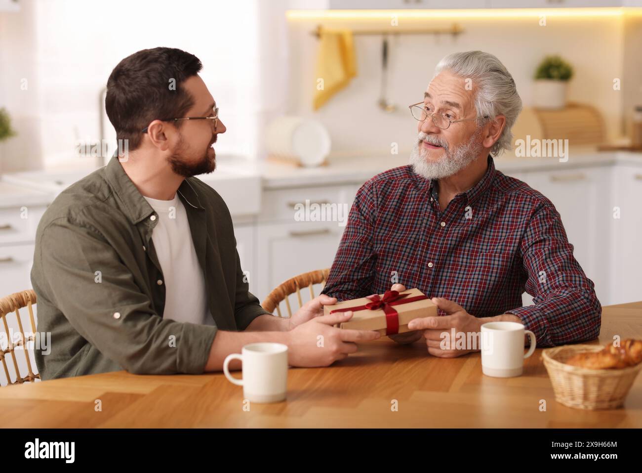 Son giving gift box to his dad at home Stock Photo - Alamy
