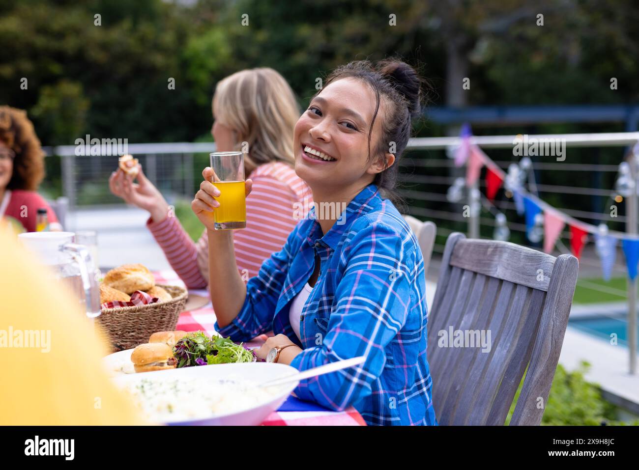 Portrait of happy diverse group of friends talking and having dinner at ...