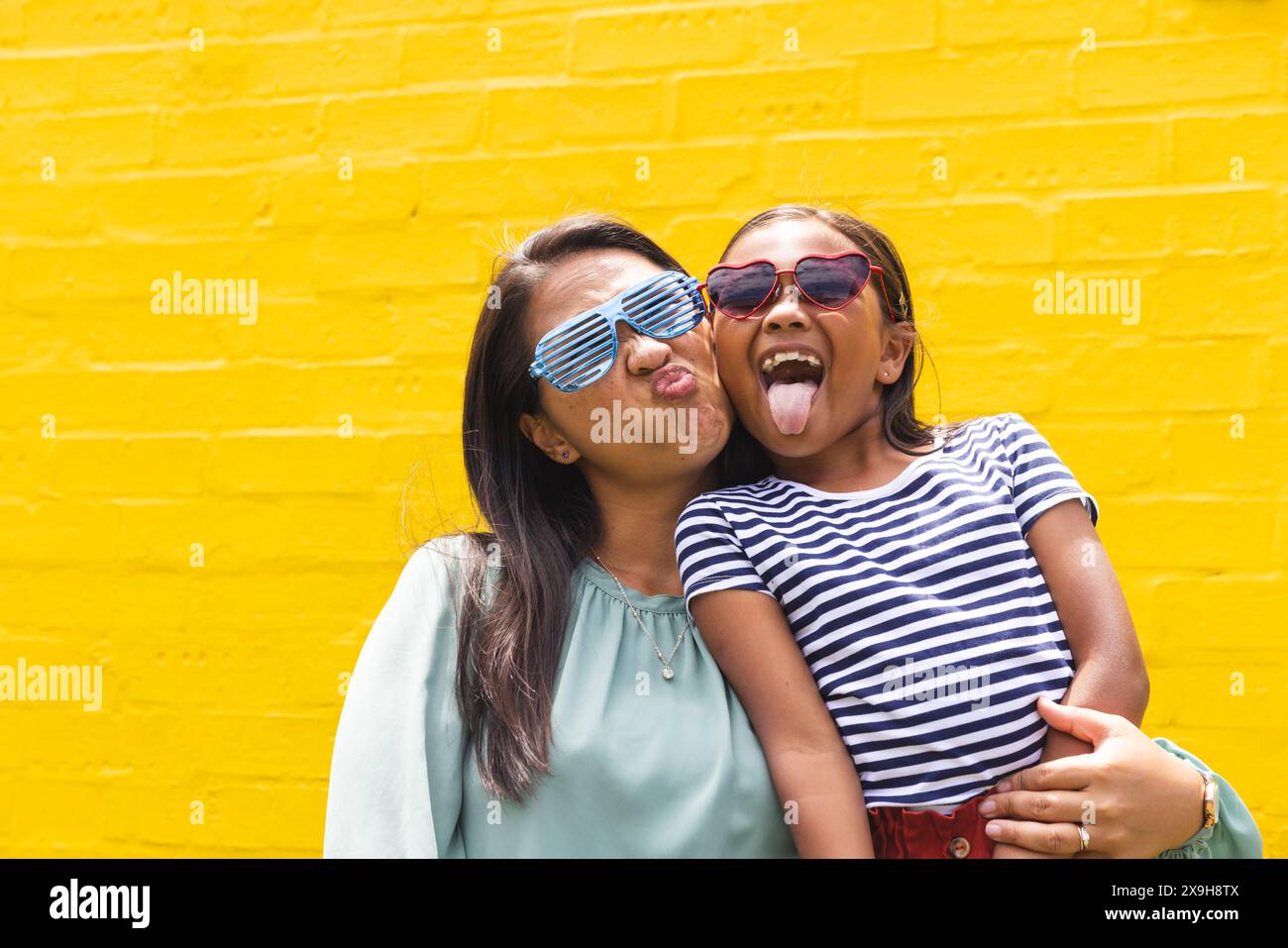 A biracial young girl wearing striped top is sticking out tongue ...