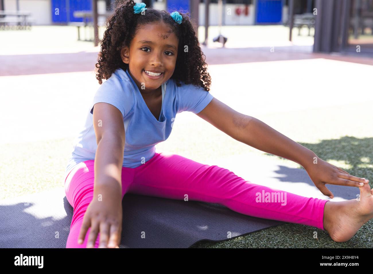 Biracial girl stretches on a mat at school Stock Photo - Alamy