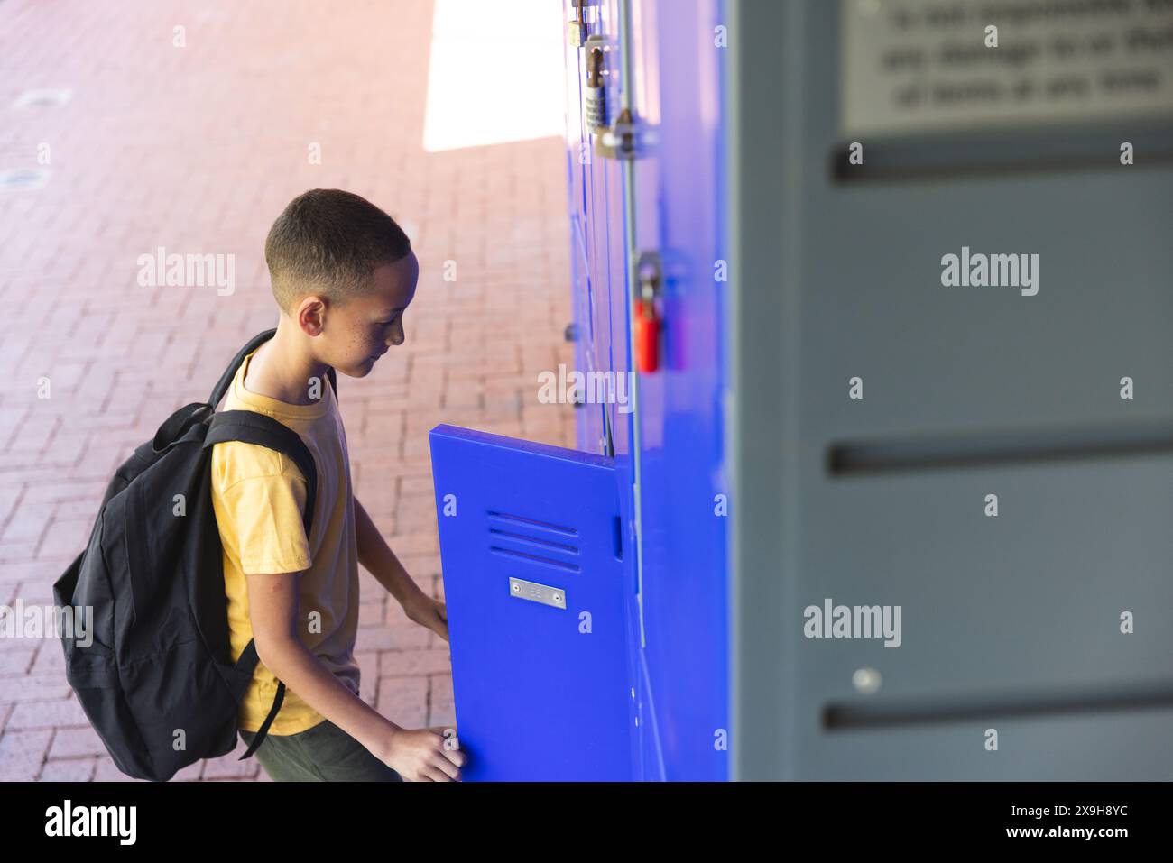 Biracial boy at school locker, with copy space Stock Photo - Alamy