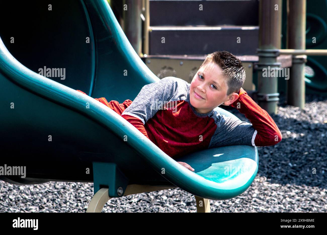 Cute little boy strikes a pose as he relaxes at the bottom of a ...