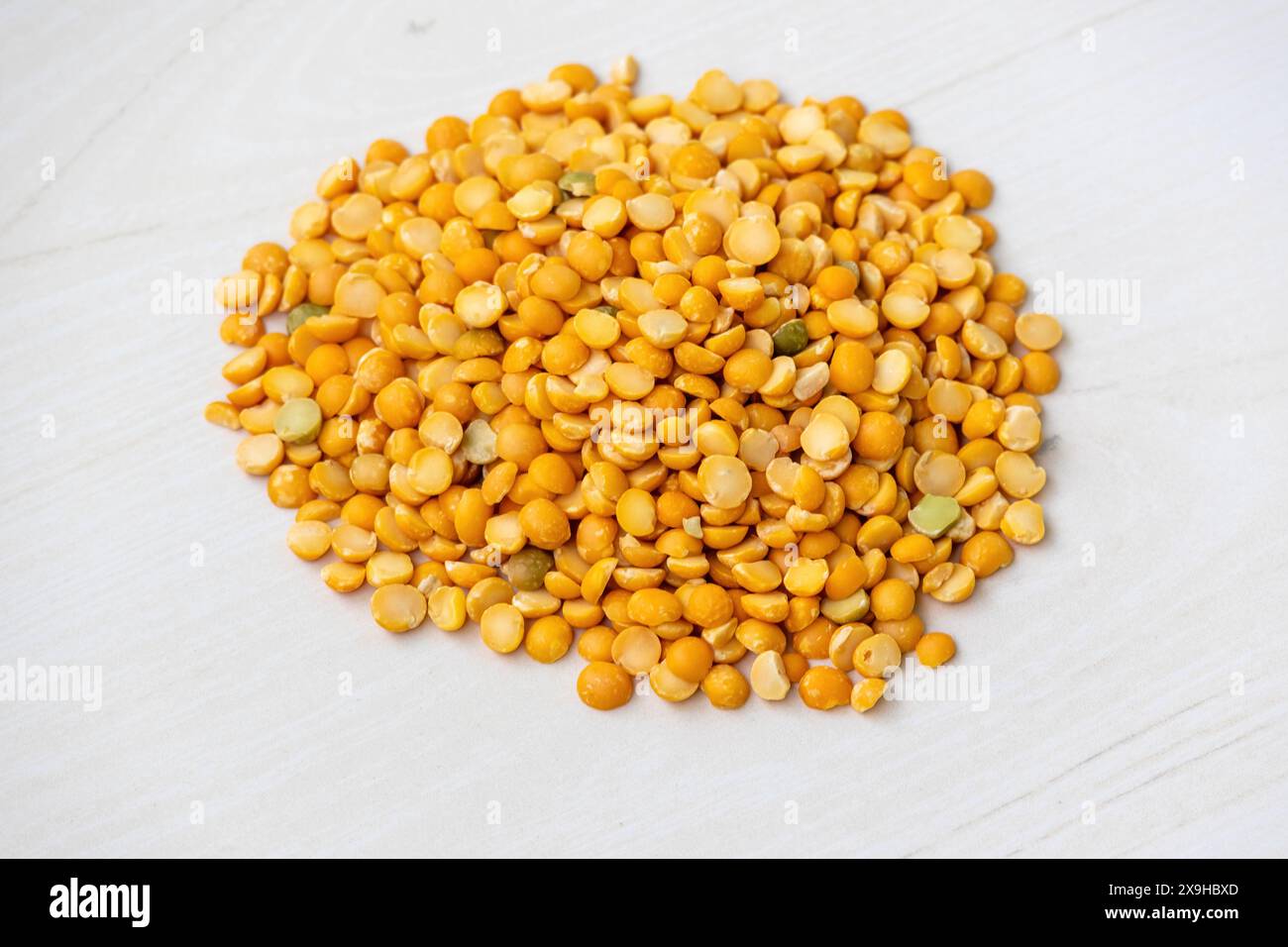 Heap of dry yellow split peas isolated on light wooden background ...