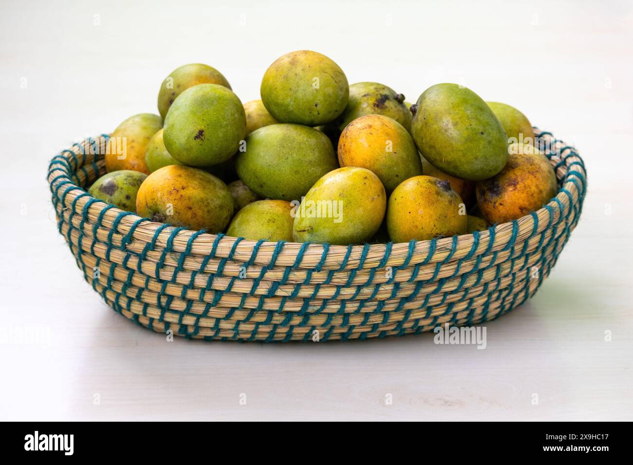 Heaps of fresh ripe mangoes on a basket. A Beautiful handmade wicker ...