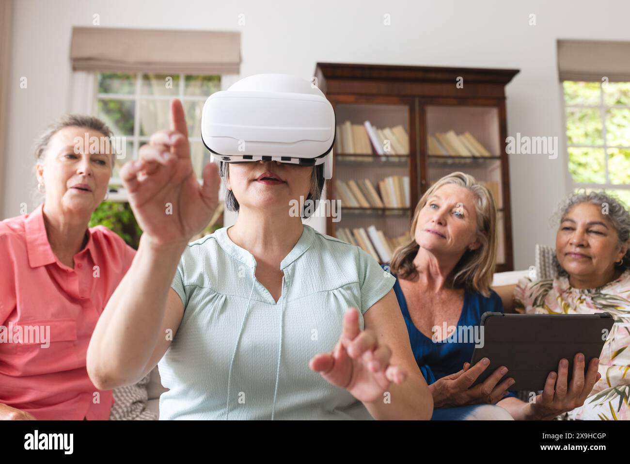 Diverse senior female friends exploring virtual reality at home Stock ...