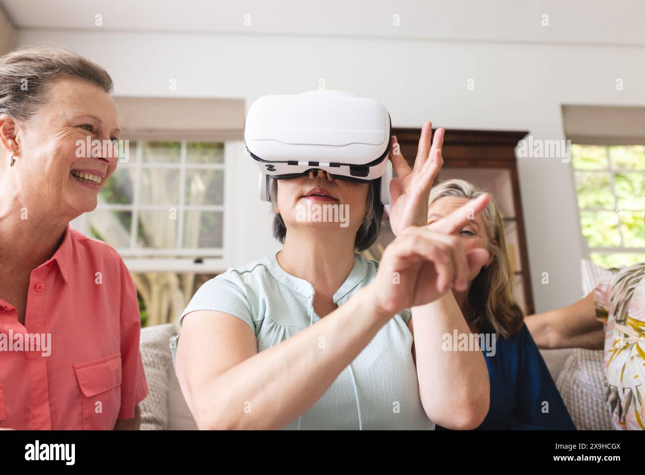 Diverse senior female friends are exploring virtual reality at home ...