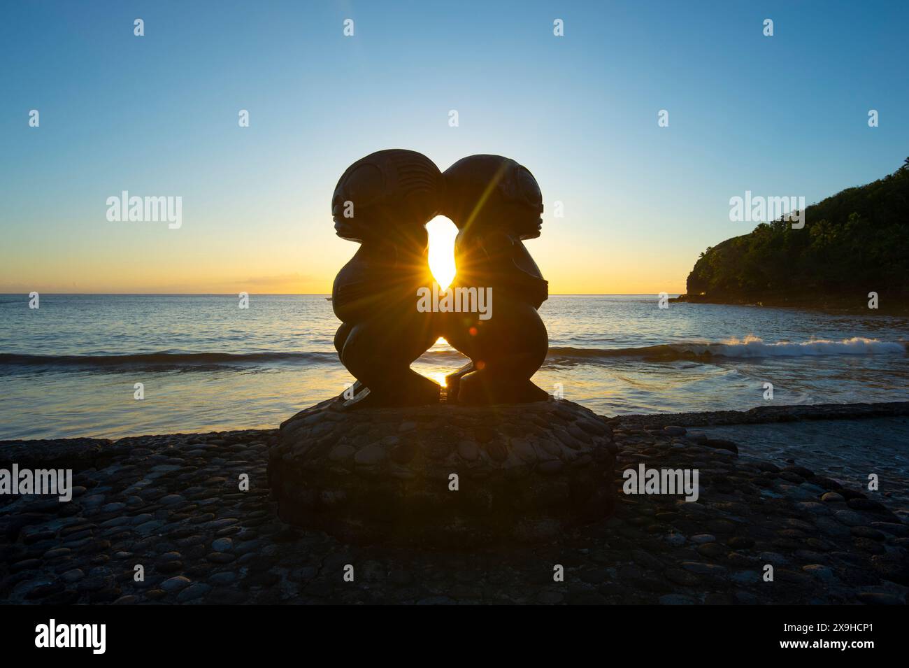 Outline of two Tiki statues at sunset in the small scenic village of ...