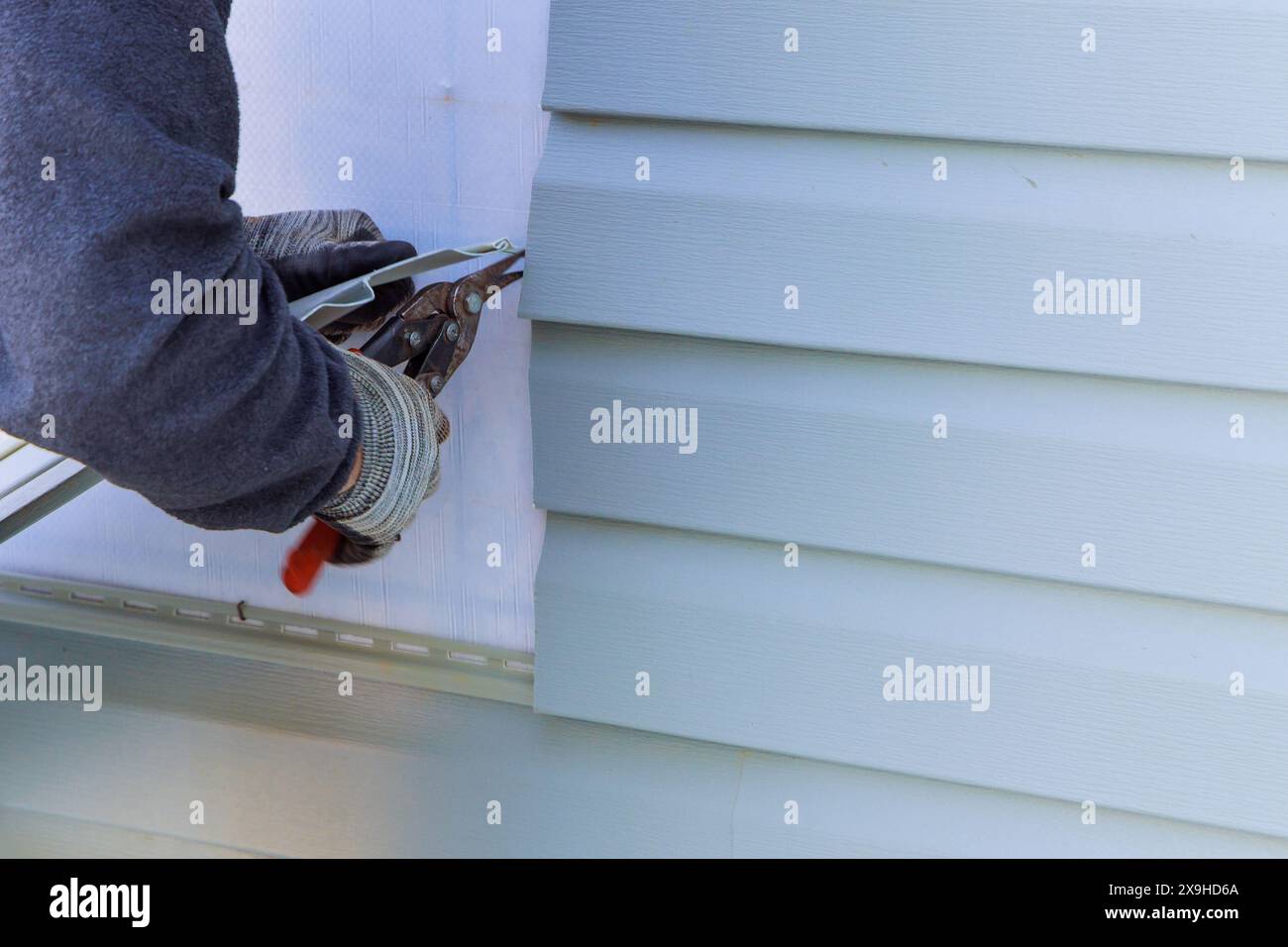 During exterior house renovations, damaged plastic siding is replaced ...