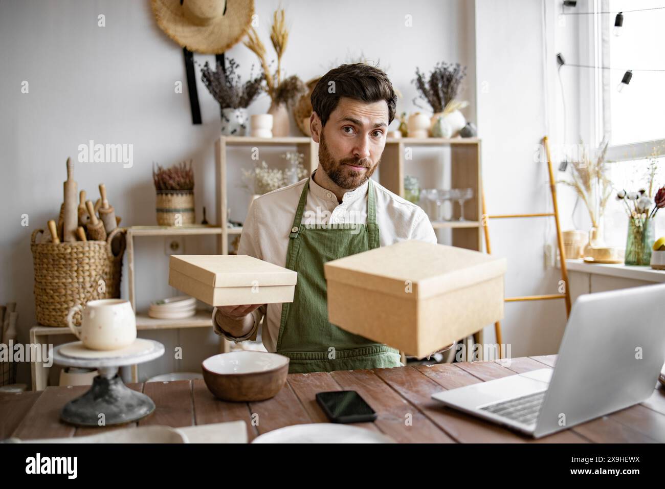 Small business owner packing his handmade product into cardboard box ...
