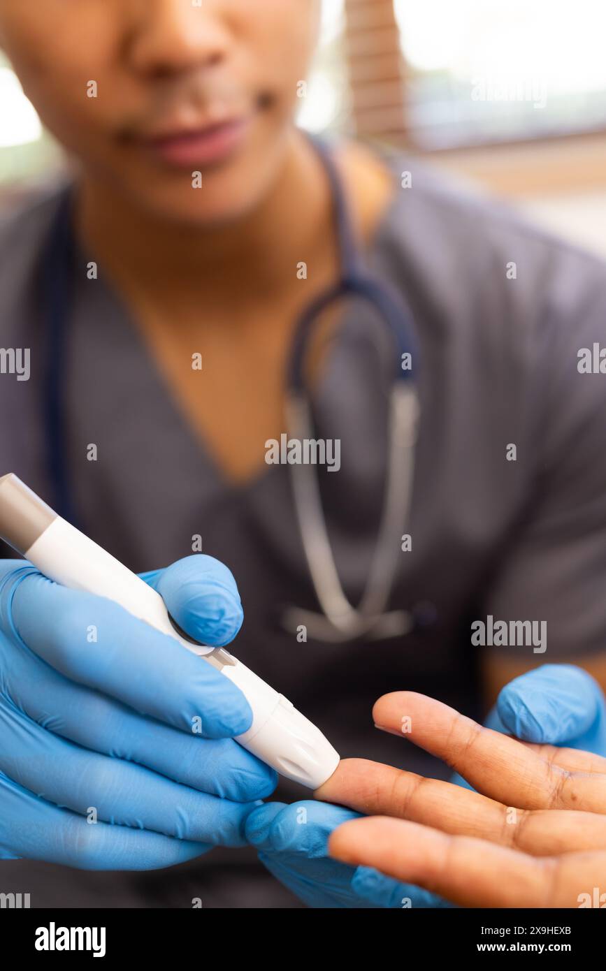 At home, young biracial male nurse treating senior female patient's ...