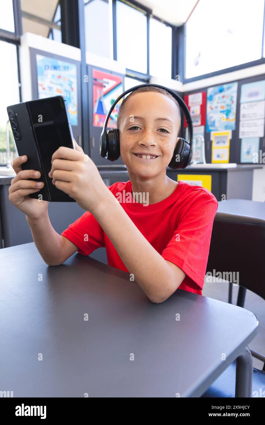 Biracial boy enjoys technology at school using a tablet Stock Photo - Alamy