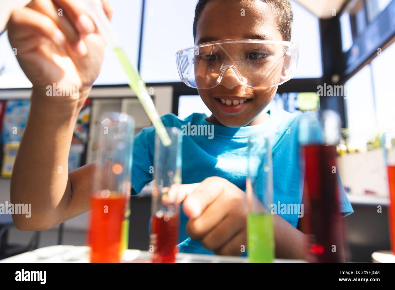 Biracial boy engaged in a science experiment at school Stock Photo - Alamy