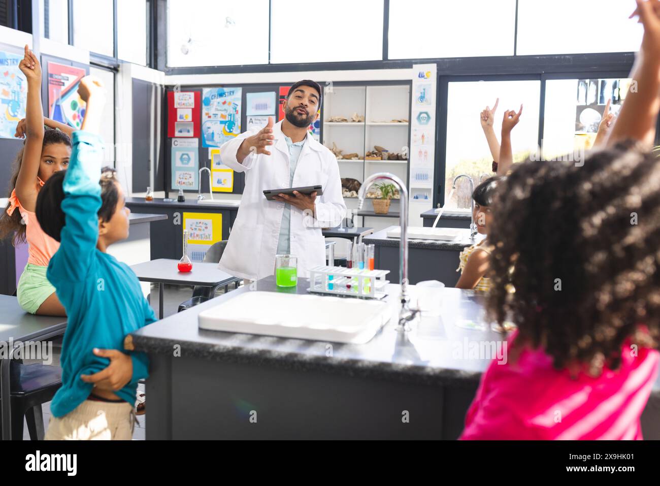 Young Asian male teacher teaching a science class in school, diverse ...