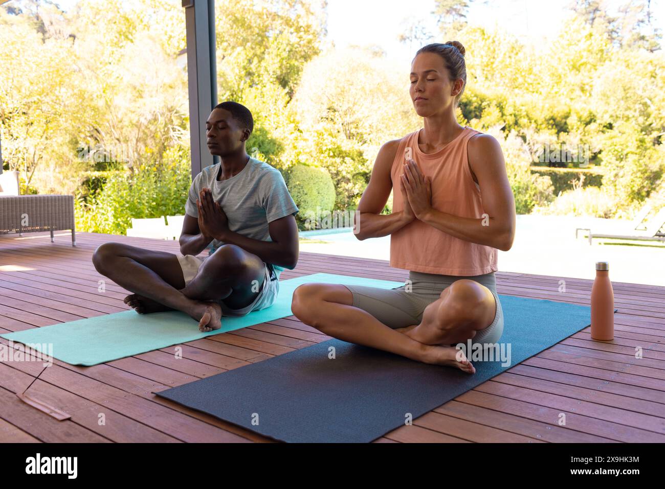 A diverse young couple meditating outside, finding peace together Stock ...