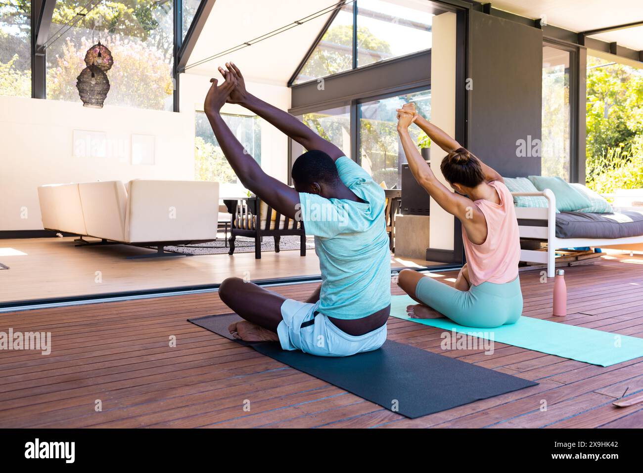 A diverse young couple stretching outside on yoga mats Stock Photo - Alamy