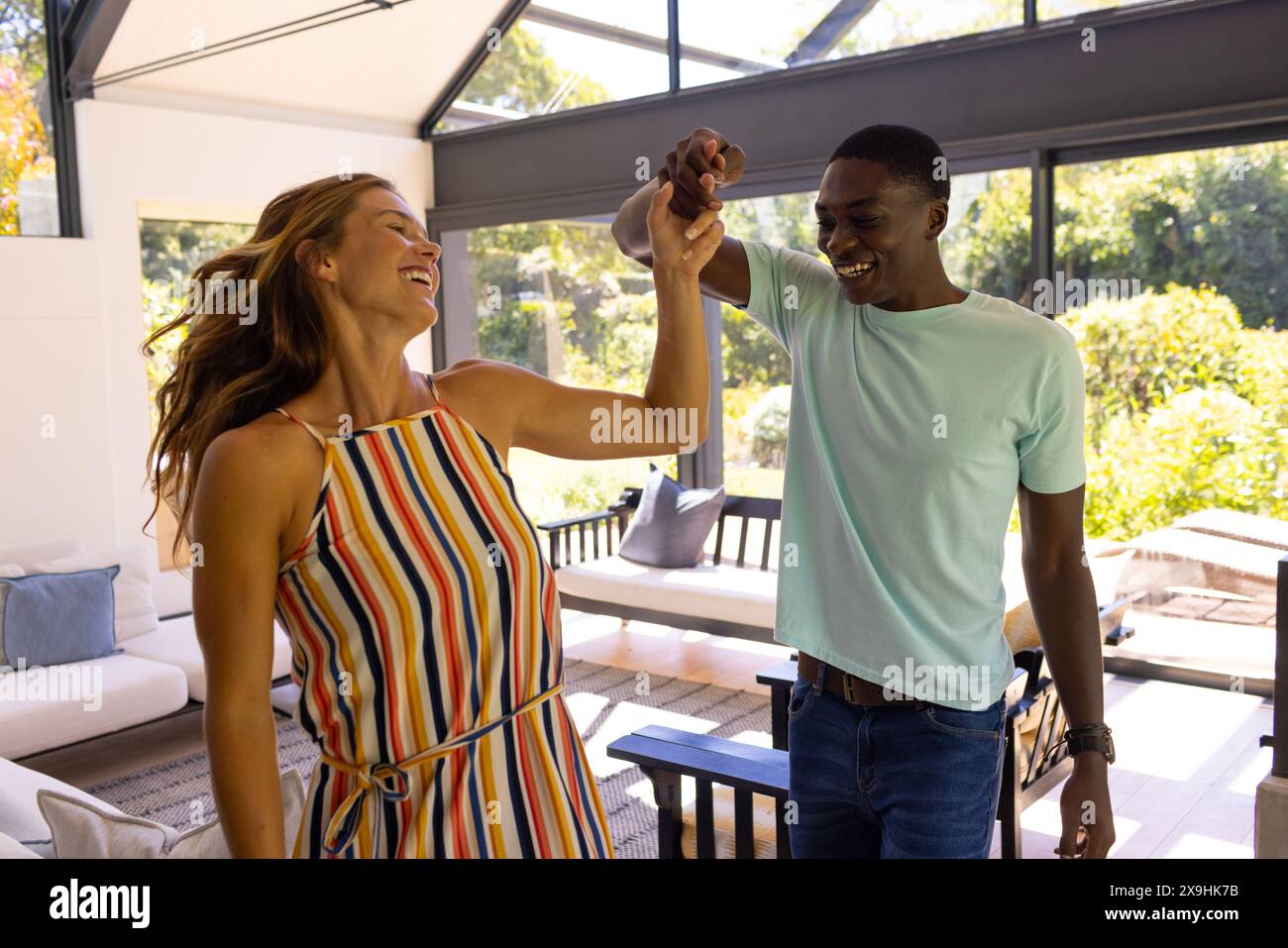 A diverse young couple dancing joyfully at home Stock Photo - Alamy
