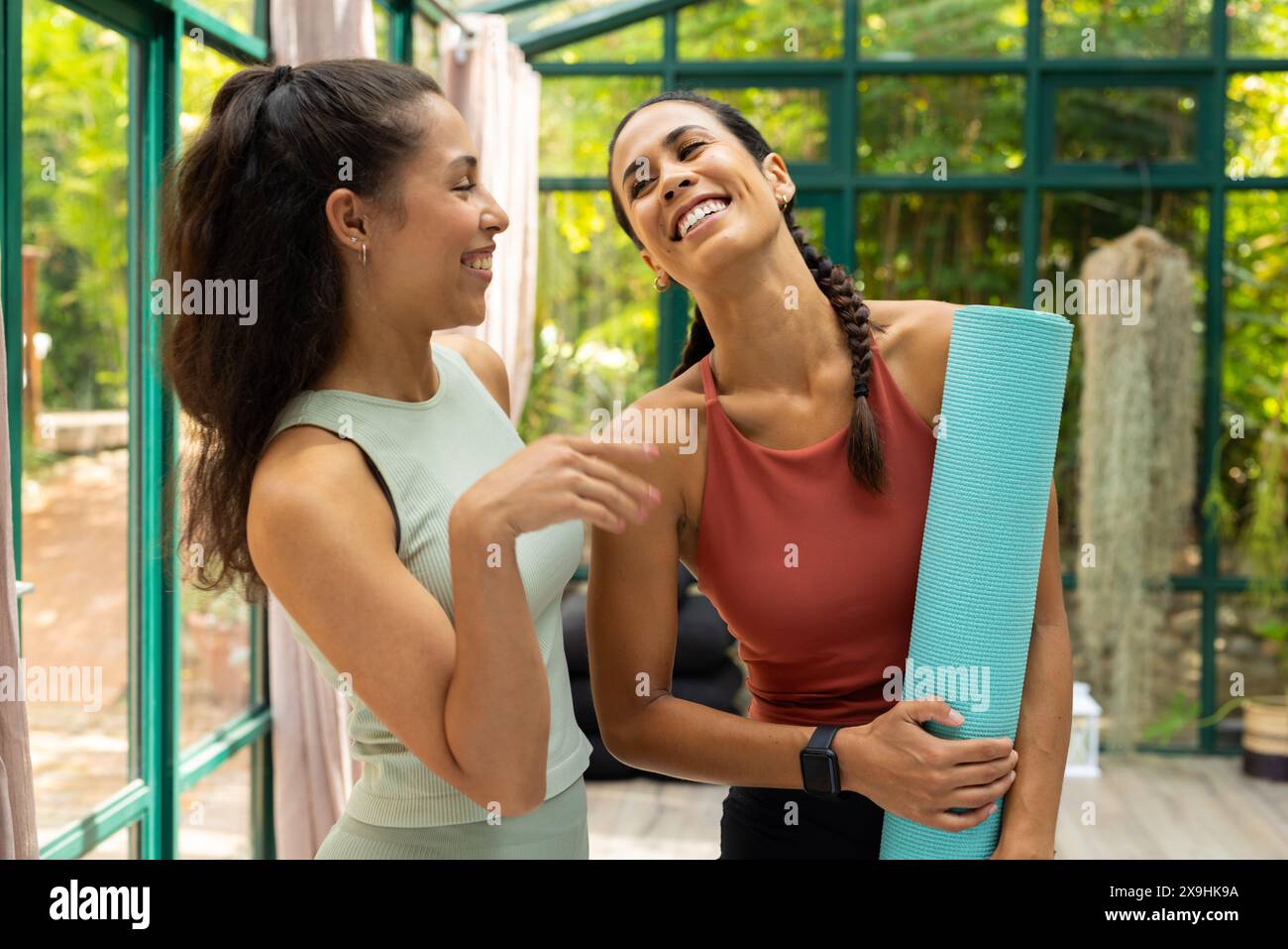 Glass house studio hosting diverse female yoga students Stock Photo - Alamy