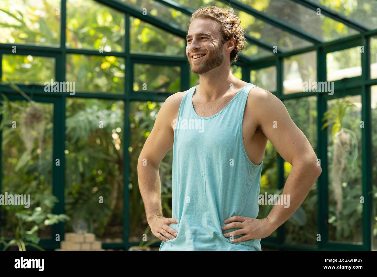 Caucasian male yoga instructor in light blue tank top standing at Glass ...
