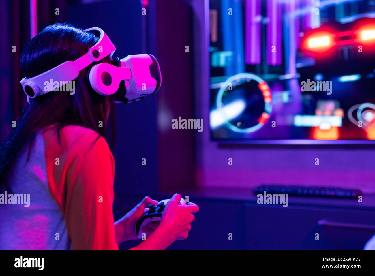 A biracial young girl at home wearing red shirt, holding a game ...