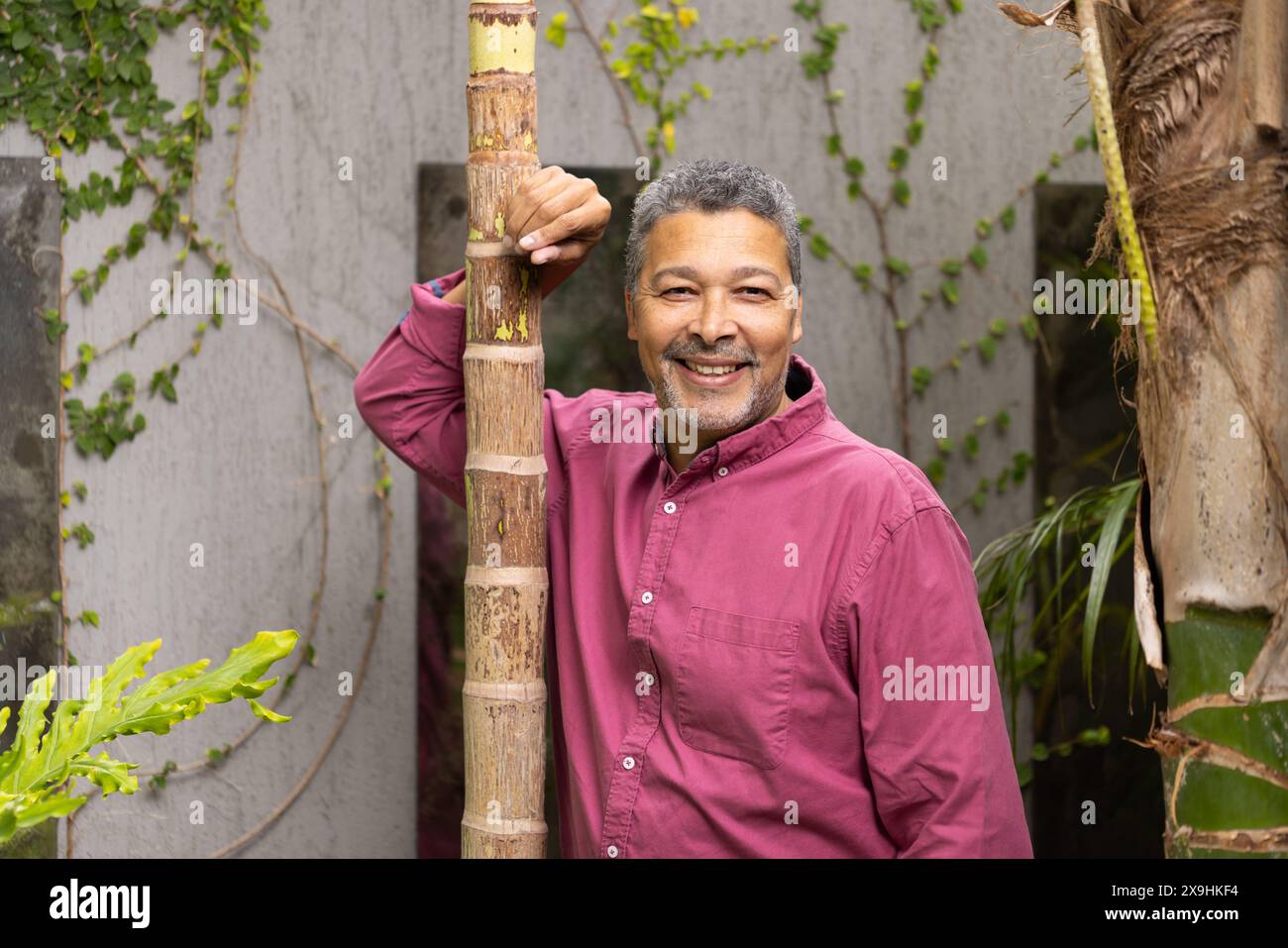 Biracial senior male with short curly gray hair and beard standing ...