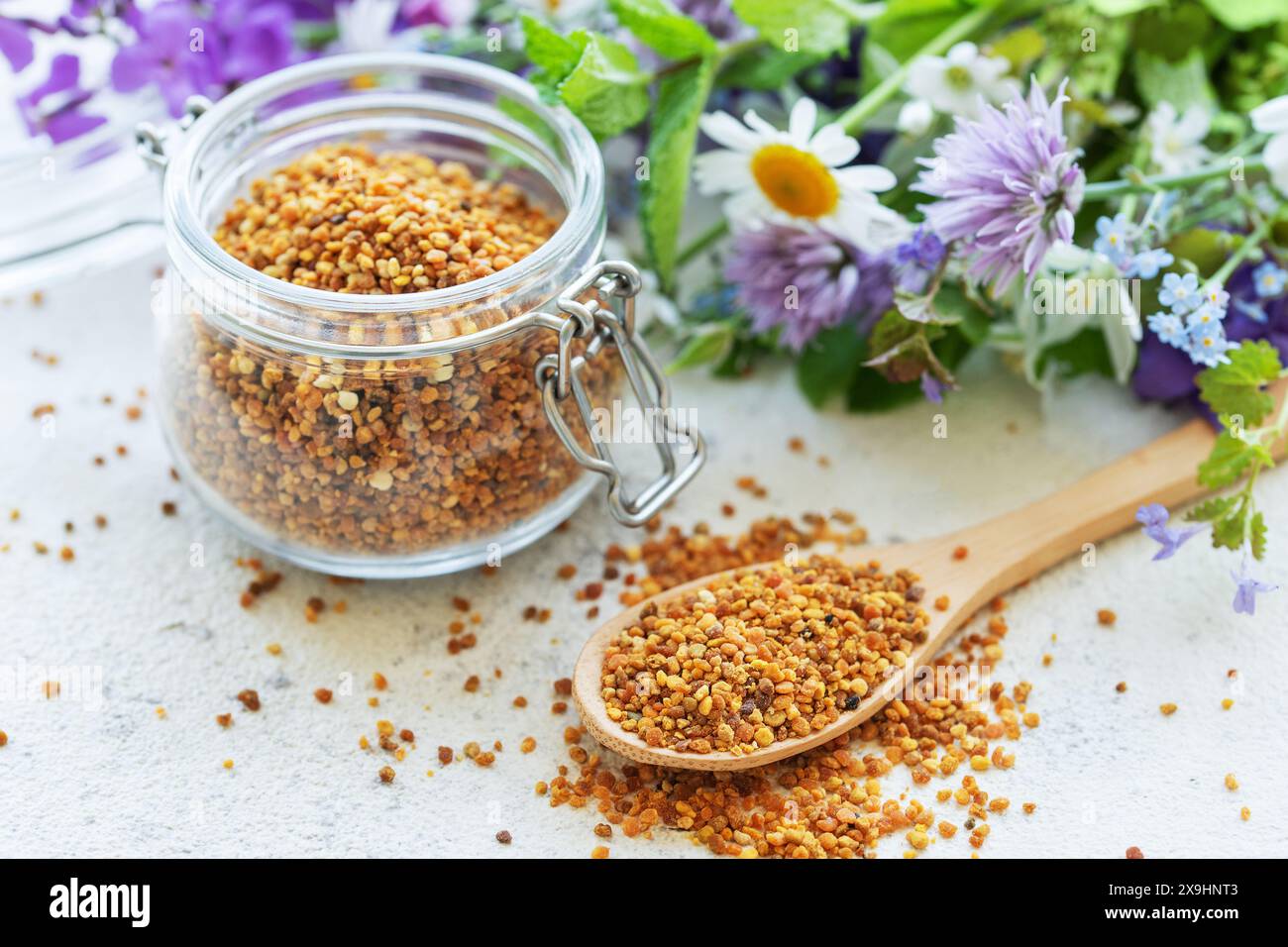 Healthy bee pollen grains. Bee pollen on a glass jar and wild flowers ...