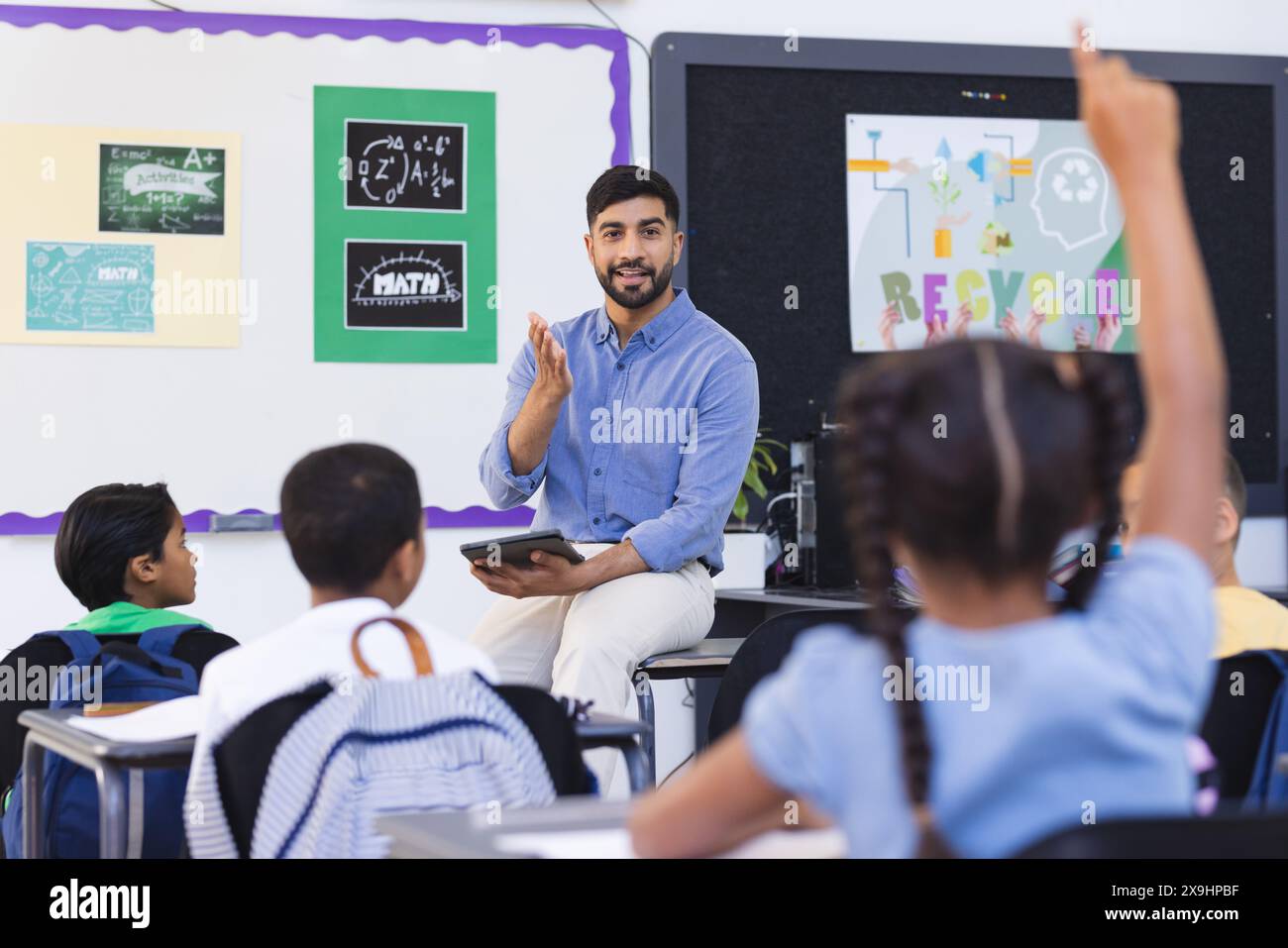 Young Asian male teacher teaching in a school classroom, students ...