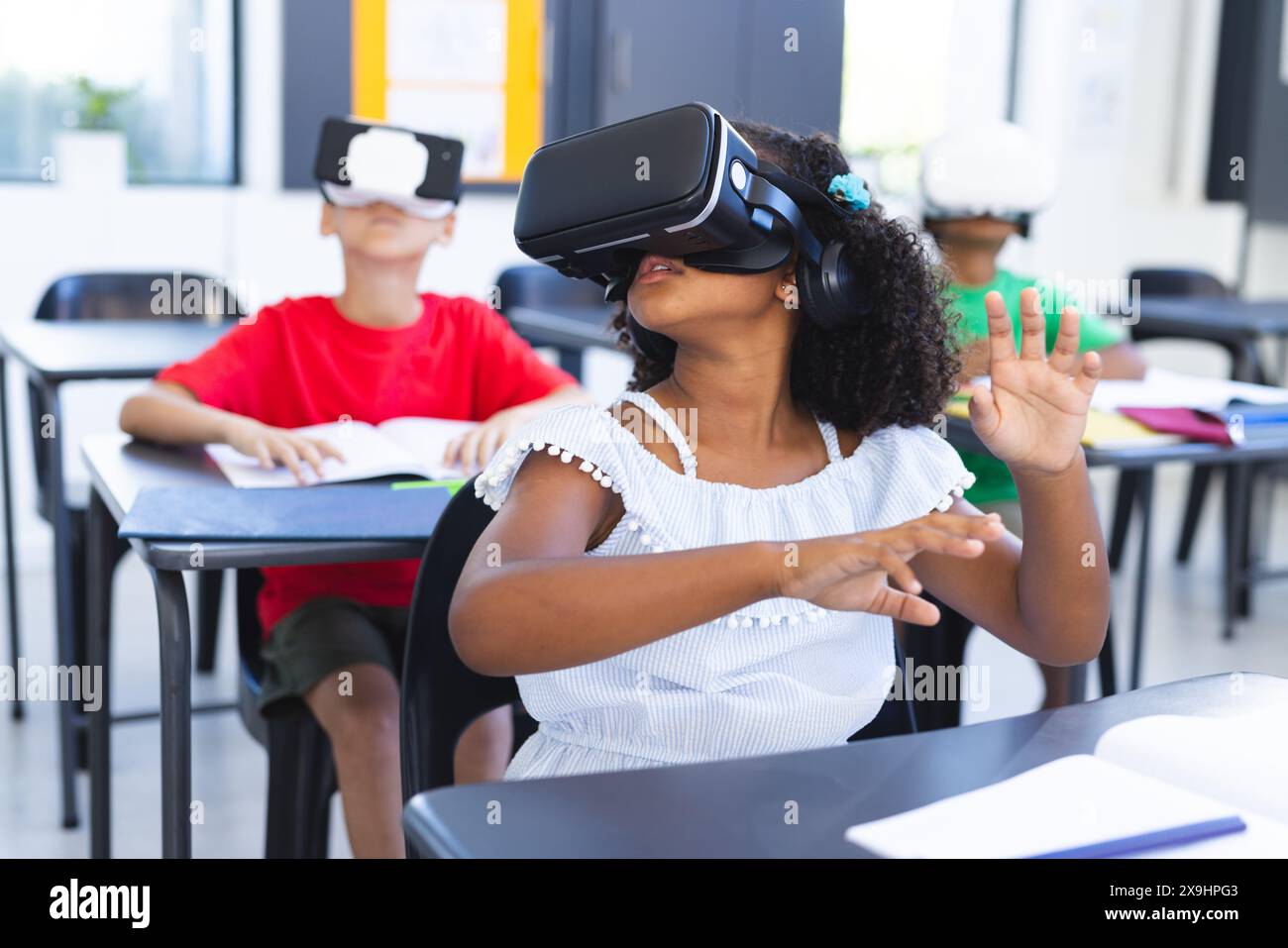 In school, young biracial female student wearing virtual reality ...