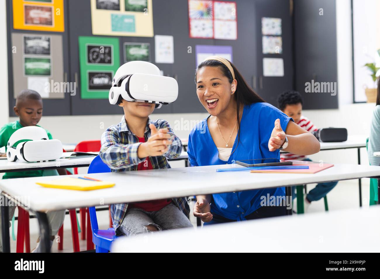 In school, diverse group of students and their teacher exploring ...