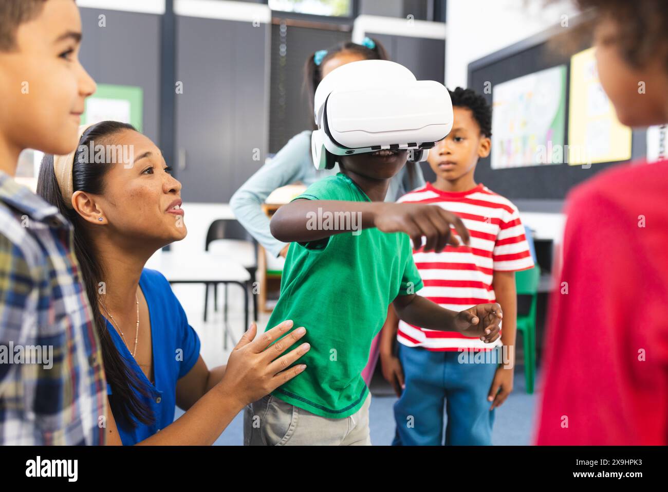 In school, diverse group of students exploring virtual reality with ...