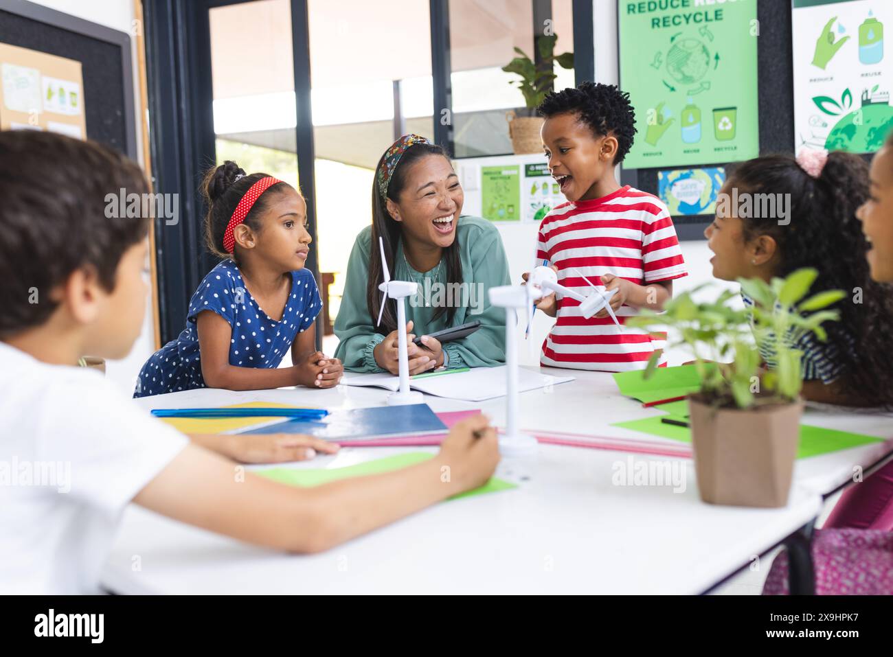 In school, middle-aged African American teacher laughing with diverse ...