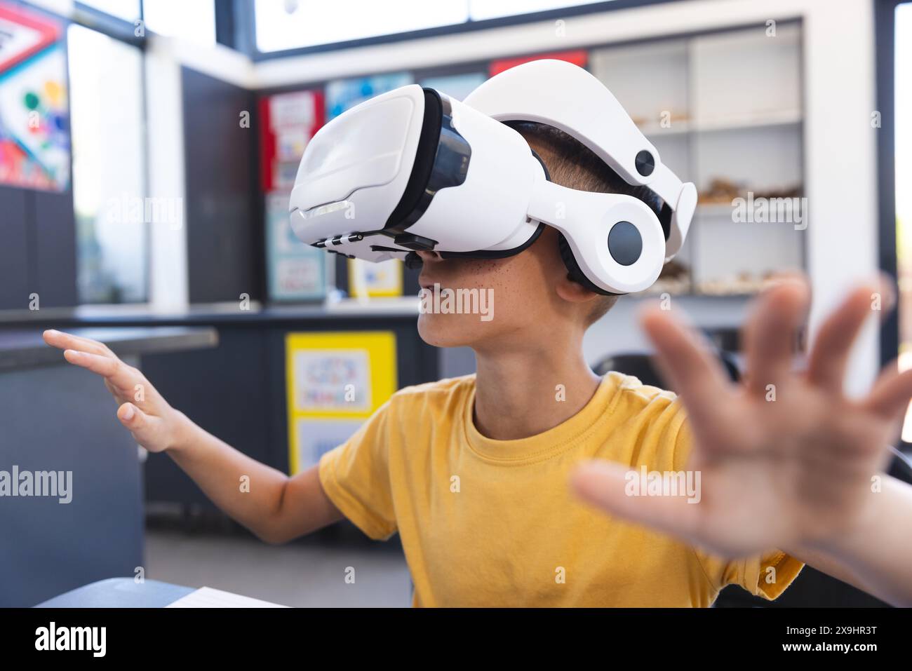 A young biracial student explores virtual reality using a headset in ...