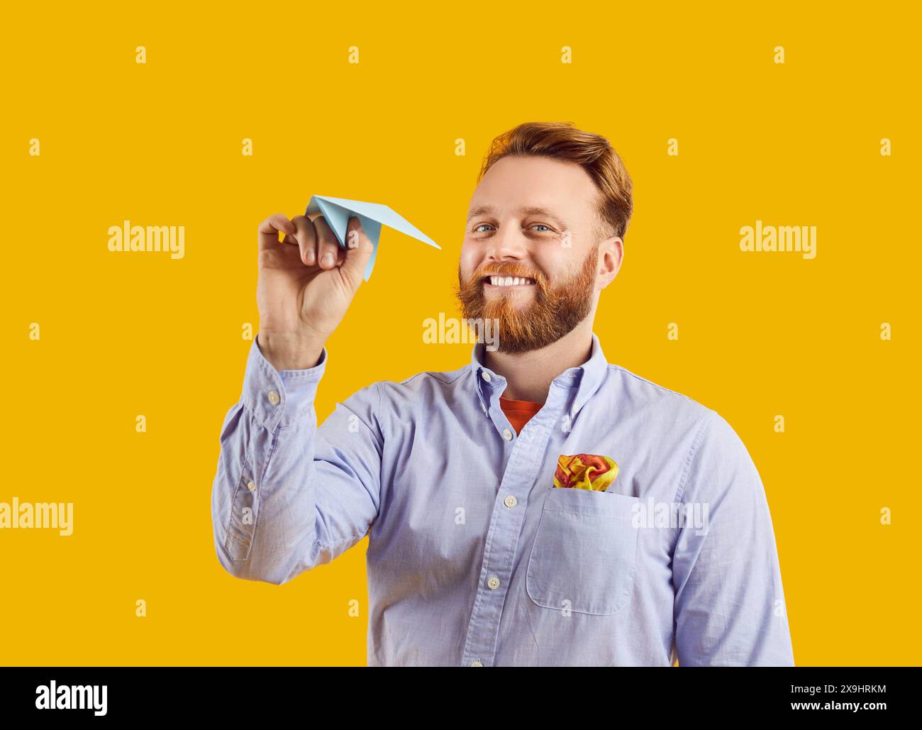 Smiling Man Launching Paper Airplane On Orange Background Stock Photo ...
