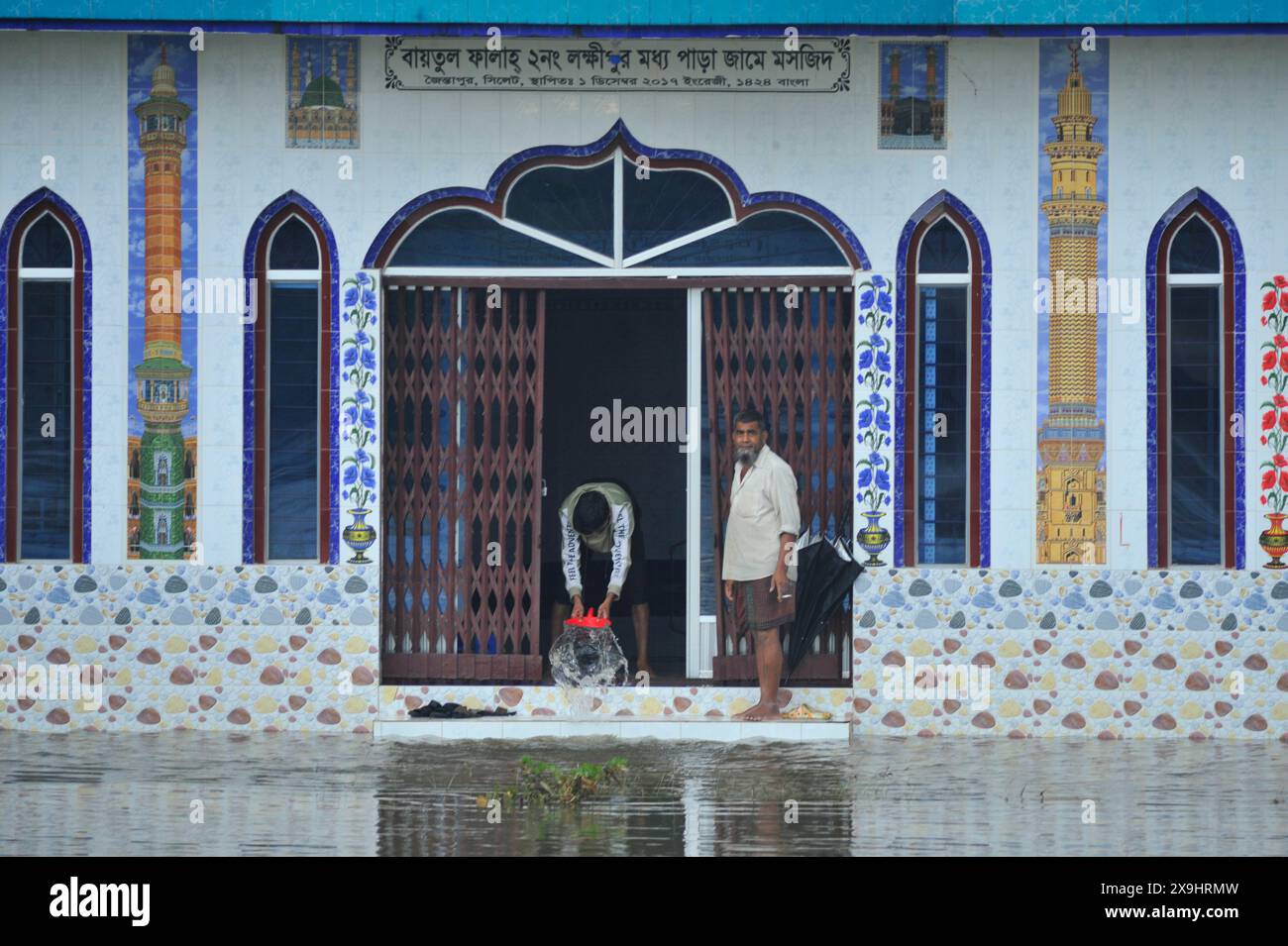 Sylhet, Bangladesh. 30th May 2024. A person tries to remove water from ...