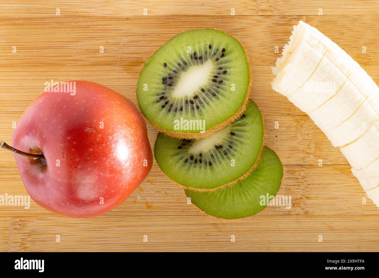 Apple, kiwi and banana cut on an wood board, healthy vegetarian vitamin ...