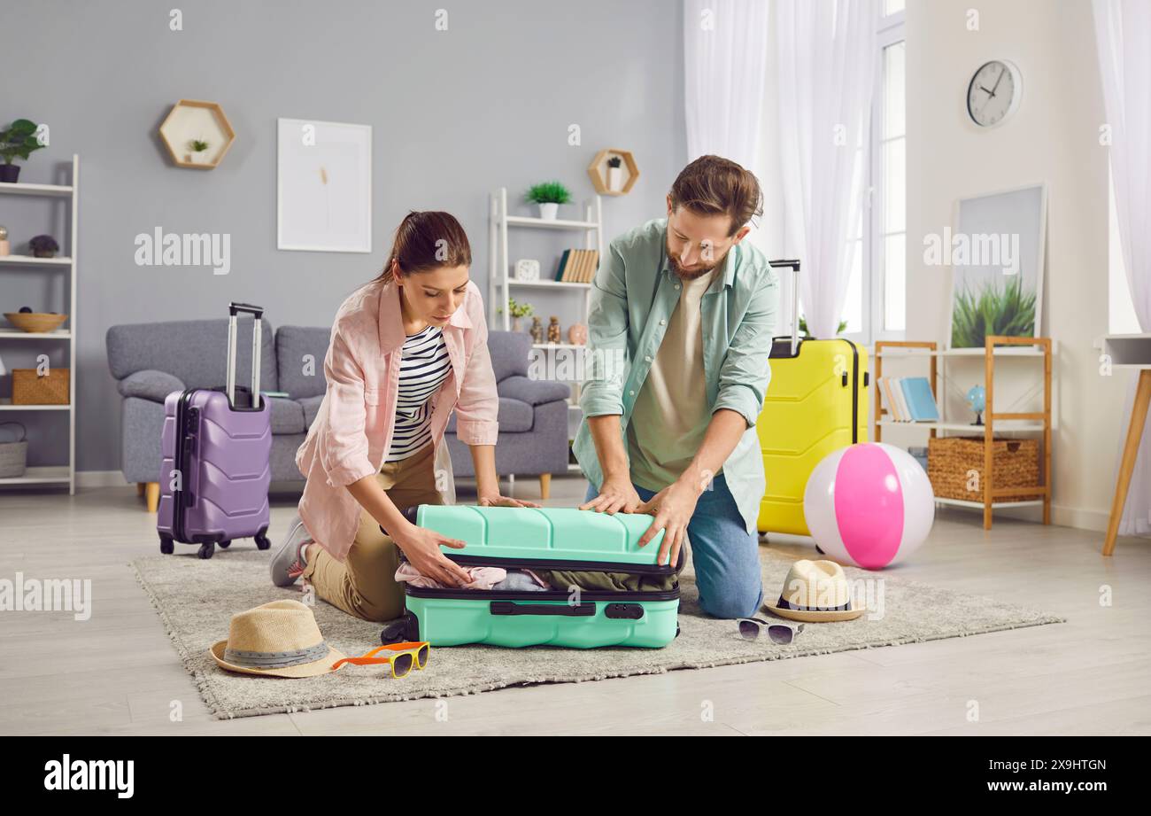 Upcoming adventure couple joyfully packing bags selecting items to pack ...
