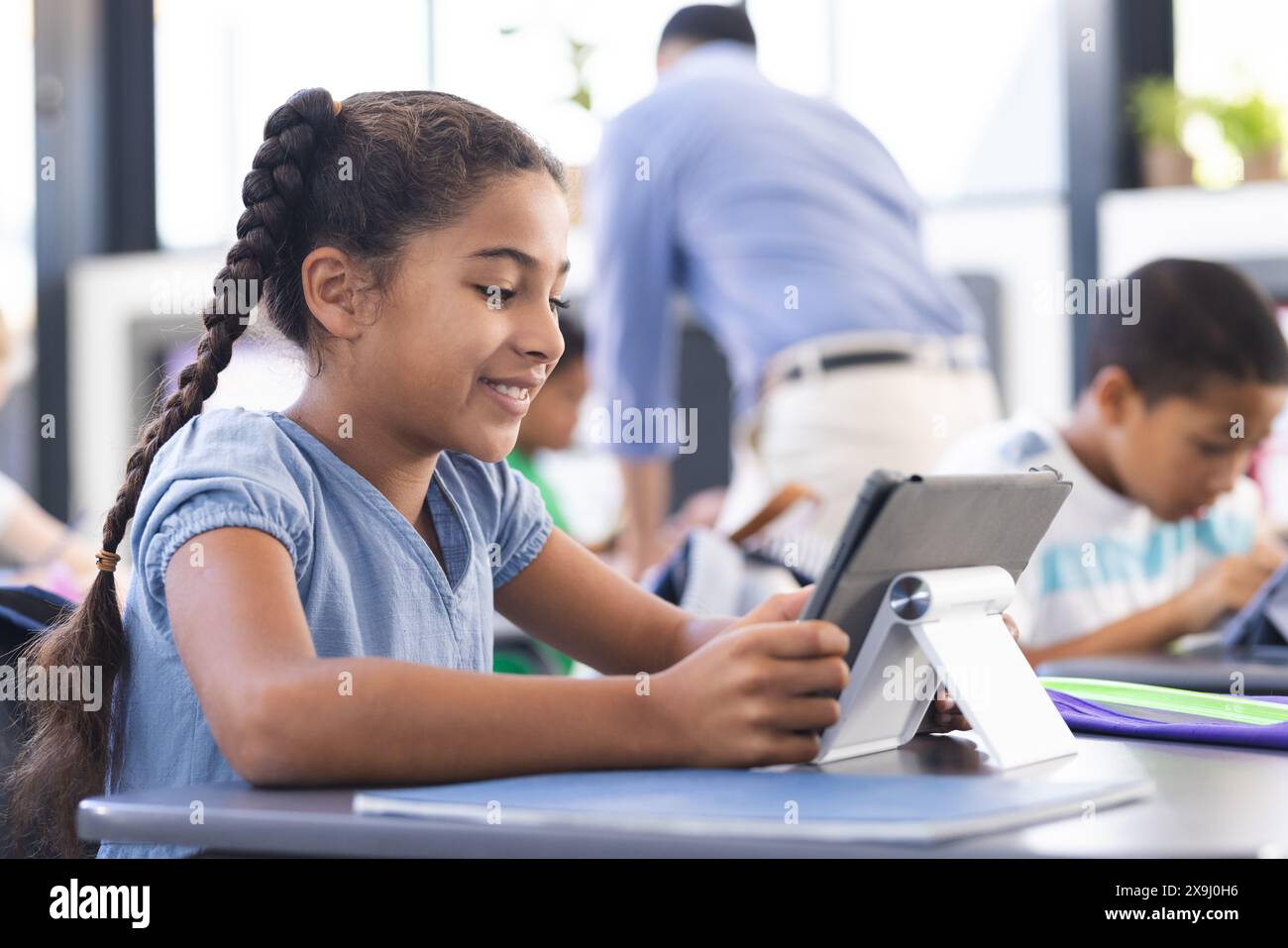 Biracial girl with braids uses tablet in class, embracing education ...