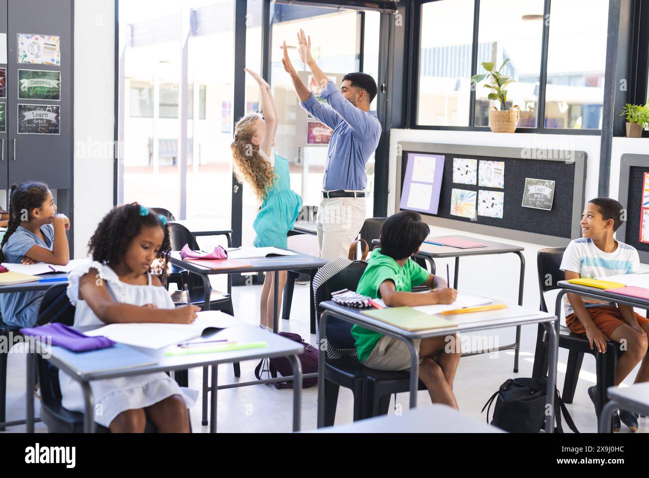 A diverse group of students learn from Asian male teacher Stock Photo ...