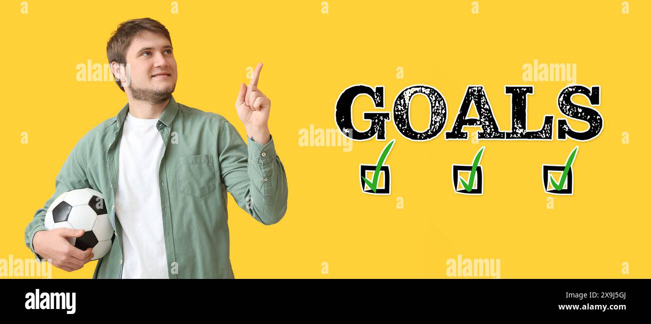 Handsome man with soccer ball pointing at something and word GOALS on ...