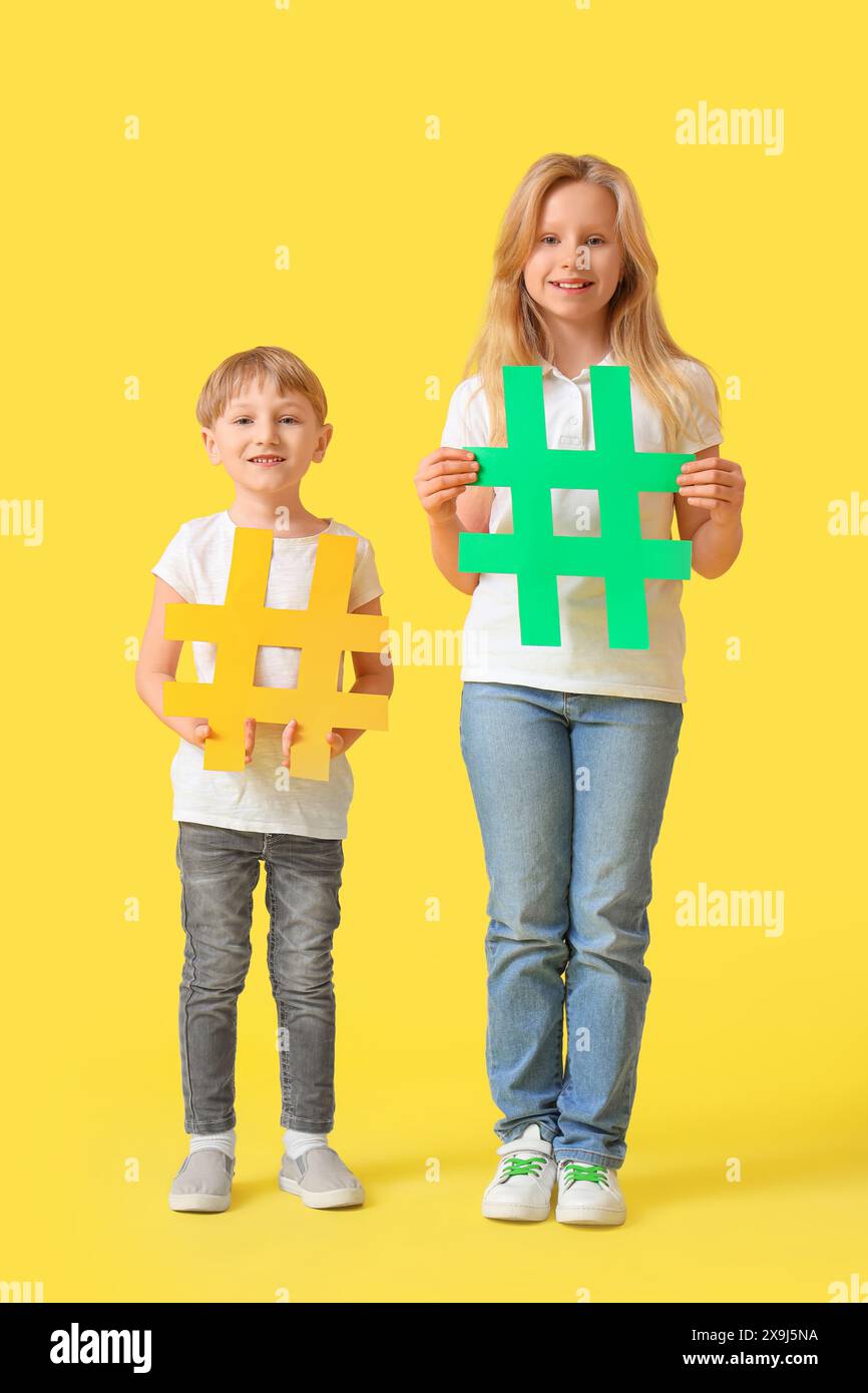 Cute kids with hashtags on yellow background Stock Photo - Alamy