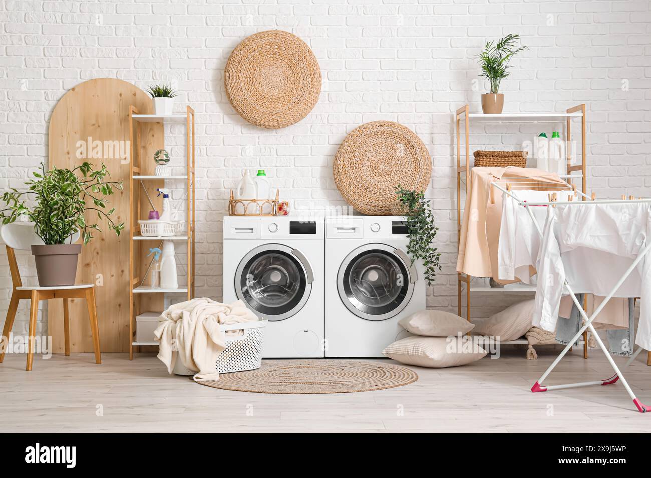 Interior of laundry room with washing machines and clean clothes on ...