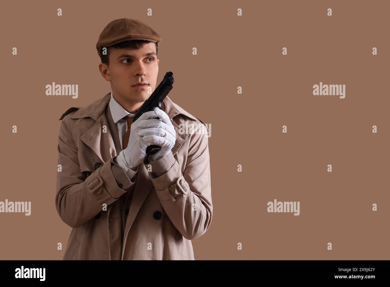 Male spy with gun on brown background Stock Photo - Alamy