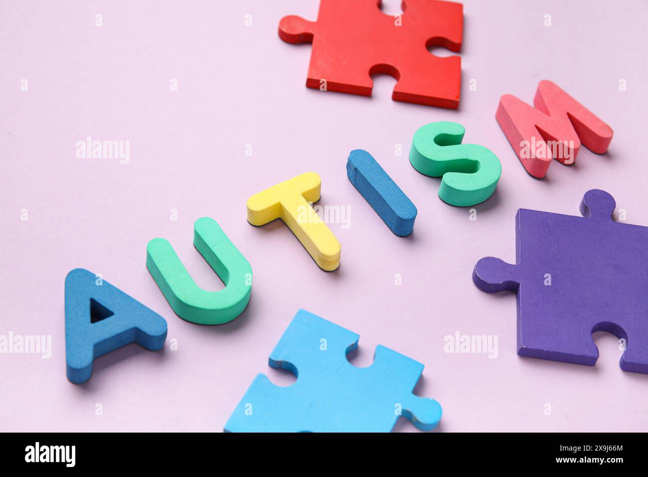 Word AUTISM, and colorful puzzle pieces on lilac background Stock Photo ...