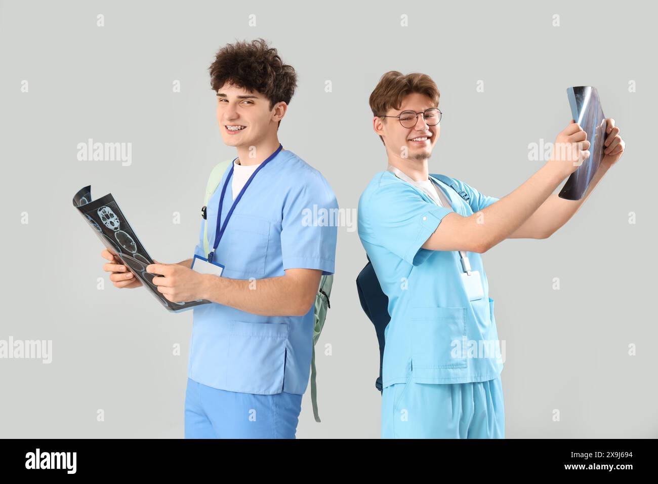 Male medical interns with x-ray scans on light background Stock Photo ...