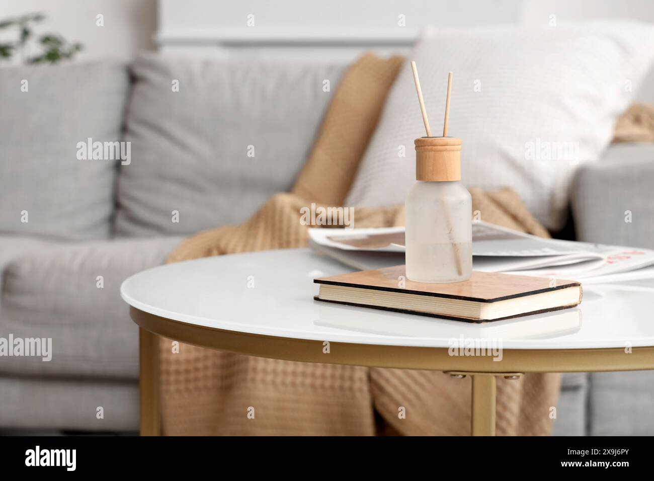 Reed diffuser, book and magazines on coffee table at home Stock Photo ...