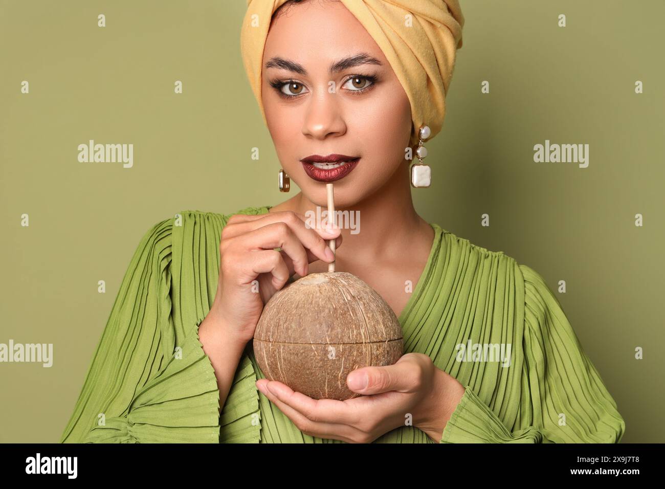 Beautiful African-American woman with coconut on green background Stock ...