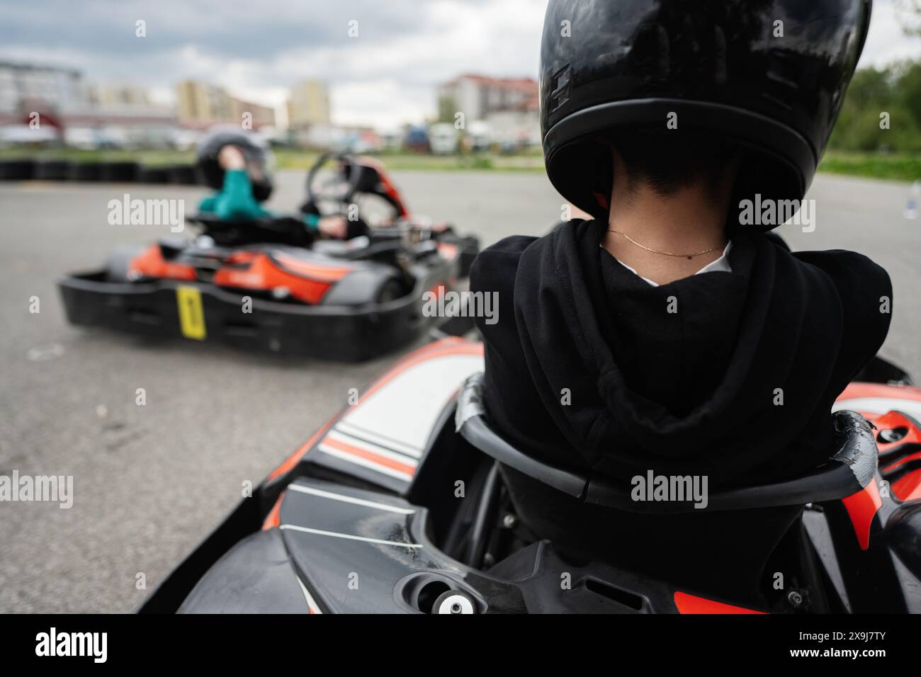 Close-up of a focused person in a black helmet driving a go-kart during ...