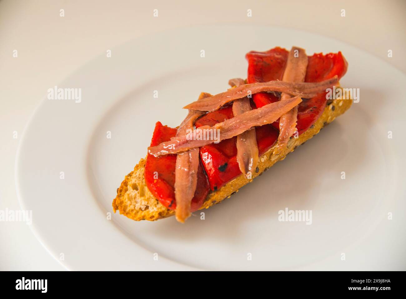Anchovy fillets with Piquillo peppers on toast. Spain Stock Photo - Alamy