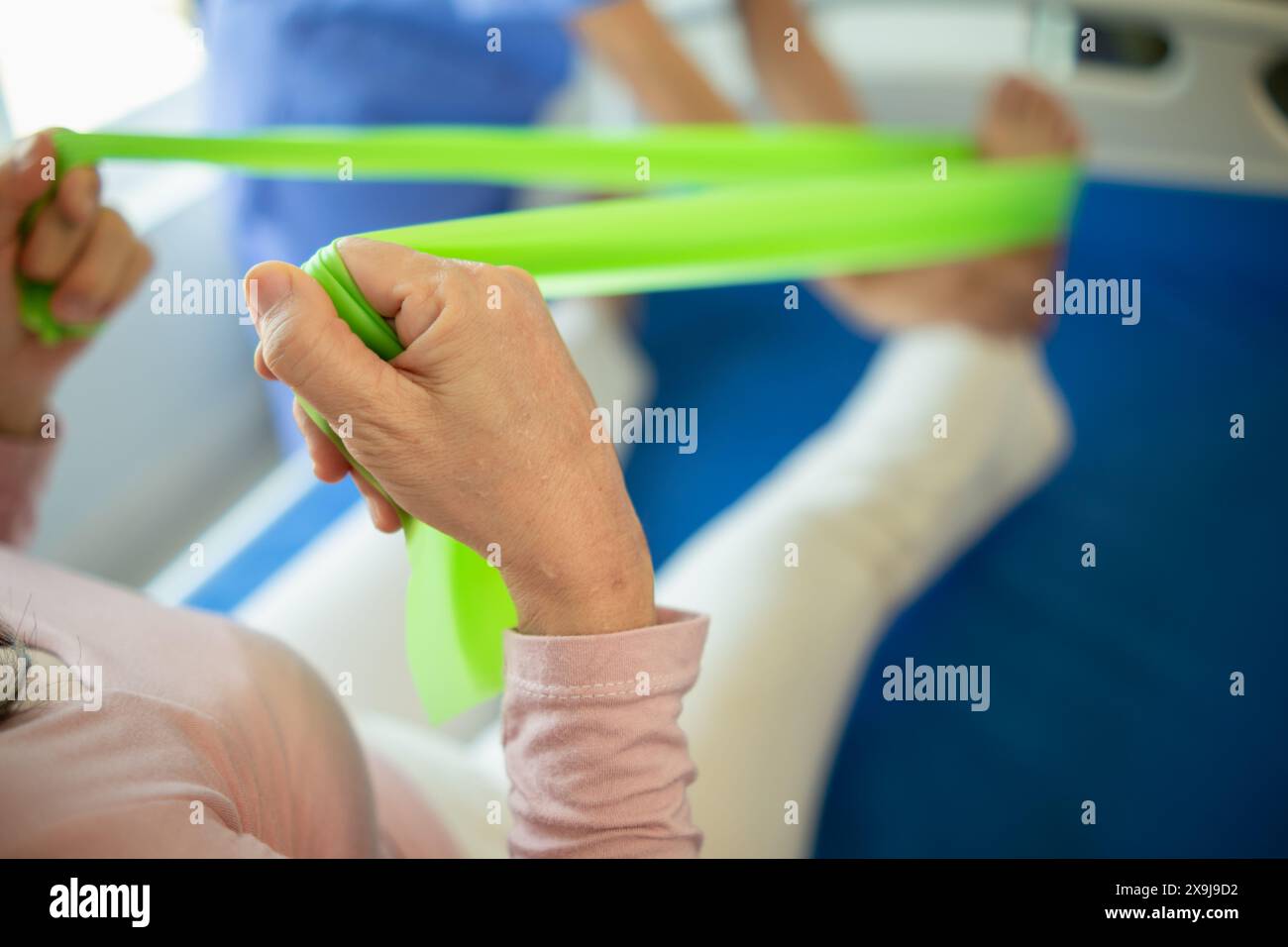 female doctor using elastic bands help patient regain muscle movement ...