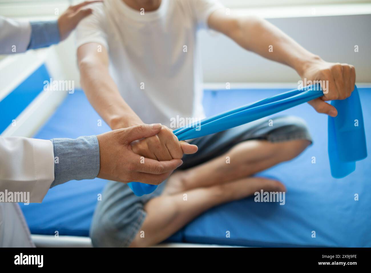 female doctor using elastic bands help patient regain muscle movement ...