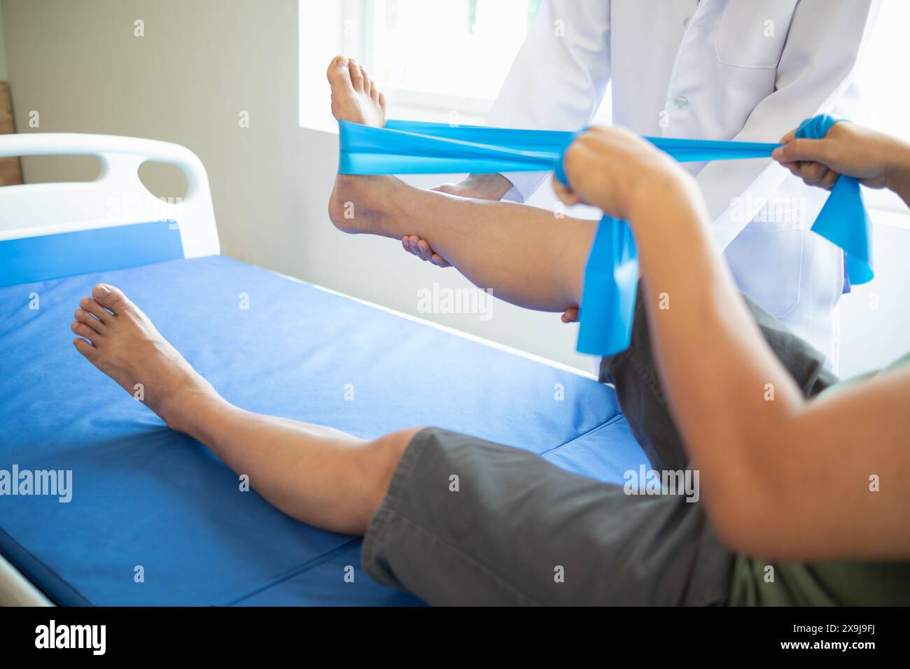 female doctor using elastic bands help patient regain muscle movement ...